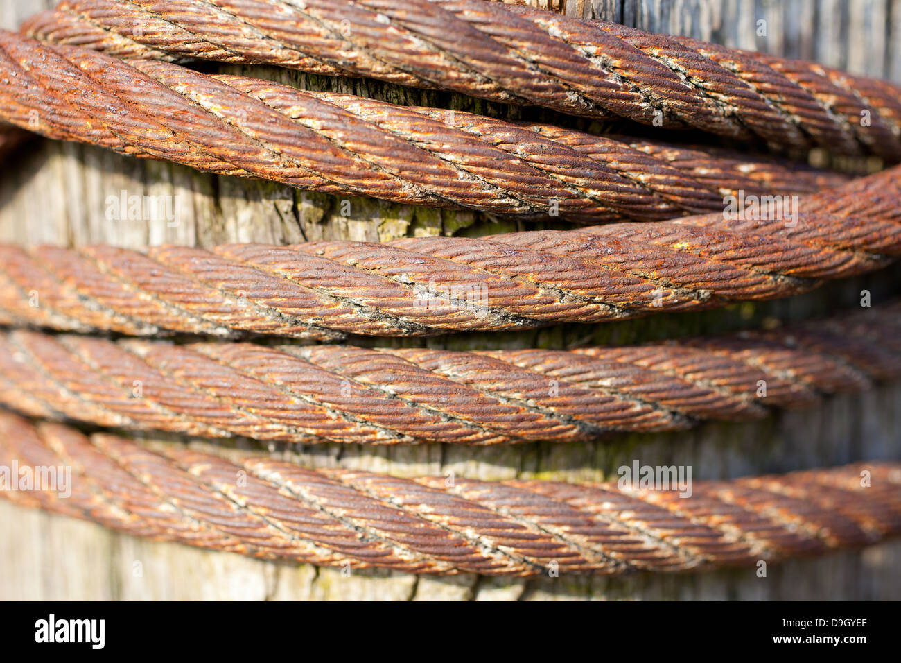 Old rusty cable wrapped around a wooden post Stock Photo - Alamy