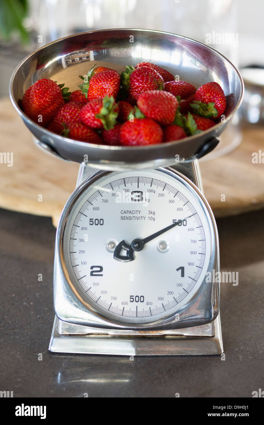 Strawberries on a weighing scale at a kitchen counter Stock Photo - Alamy