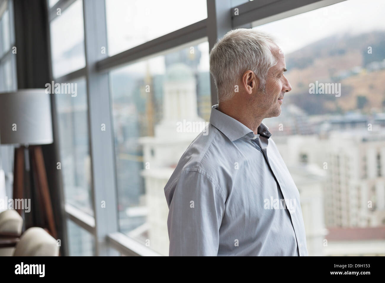 Man looking through a window Stock Photo - Alamy