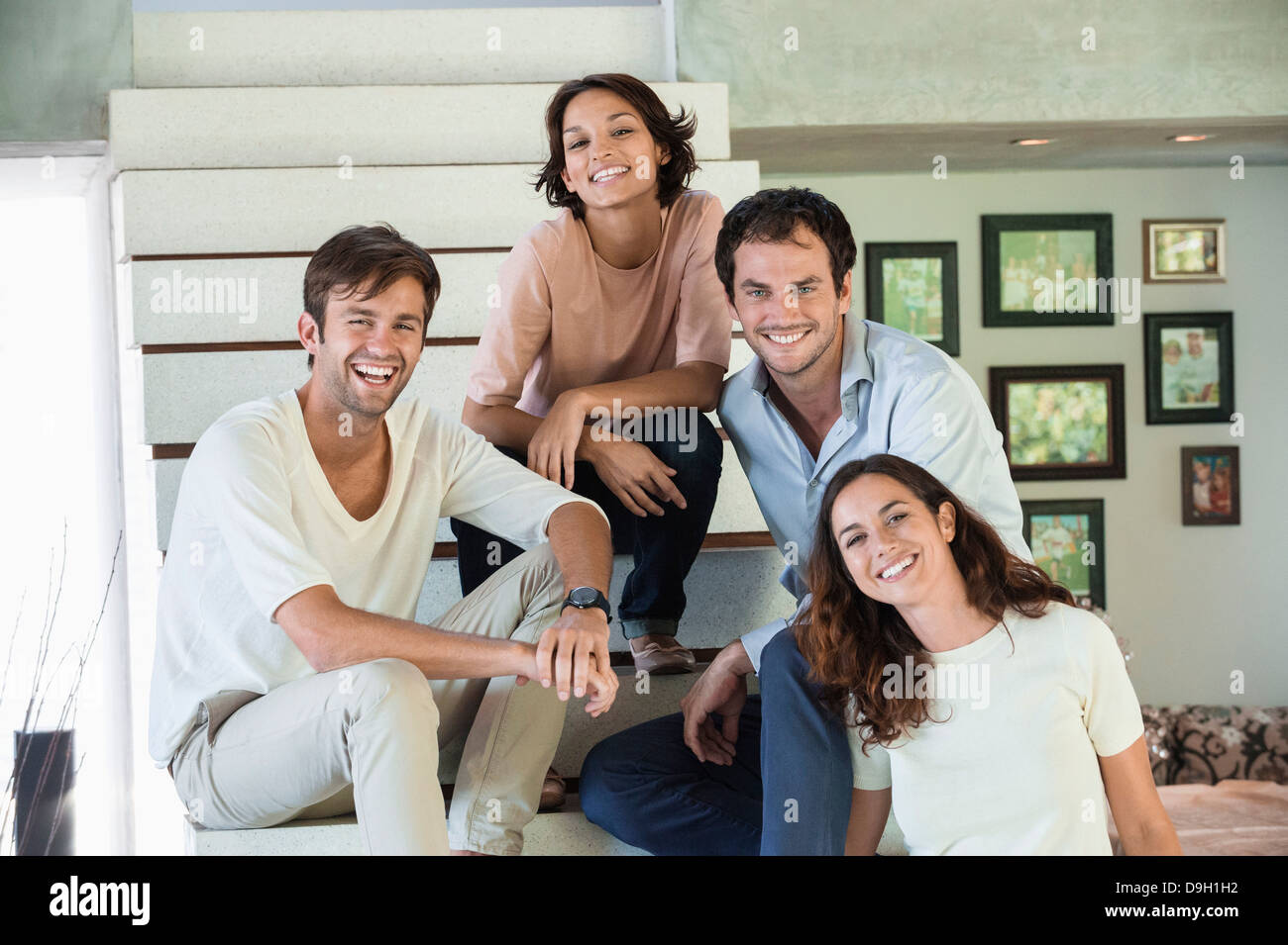 Portrait of smiling friends sitting on steps Stock Photo - Alamy