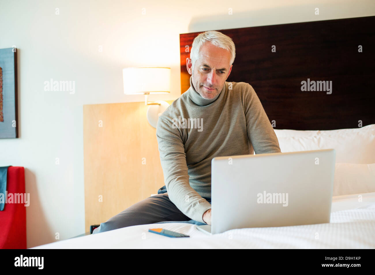 Man using a laptop in a hotel room Stock Photo - Alamy