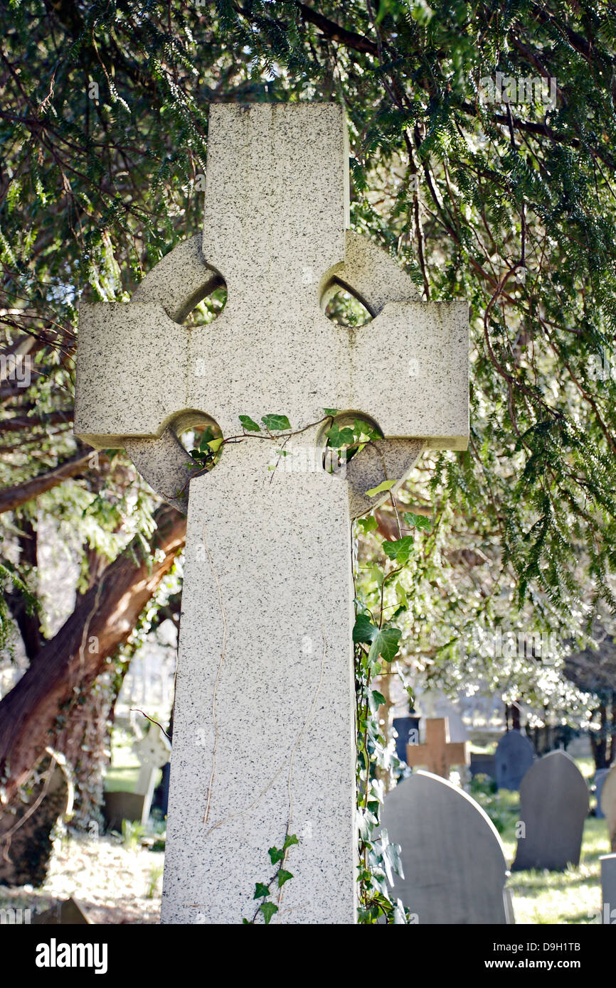 A Grave Stone in the form of a Celtic Cross under a tree Stock Photo ...