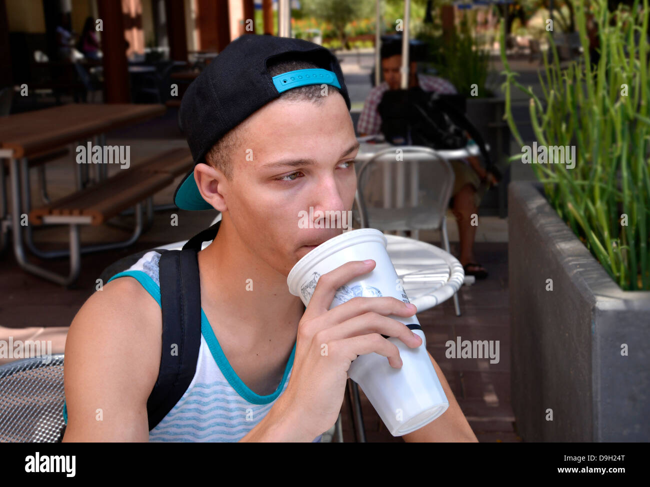 A young man drinks soda on a college campus Stock Photo - Alamy