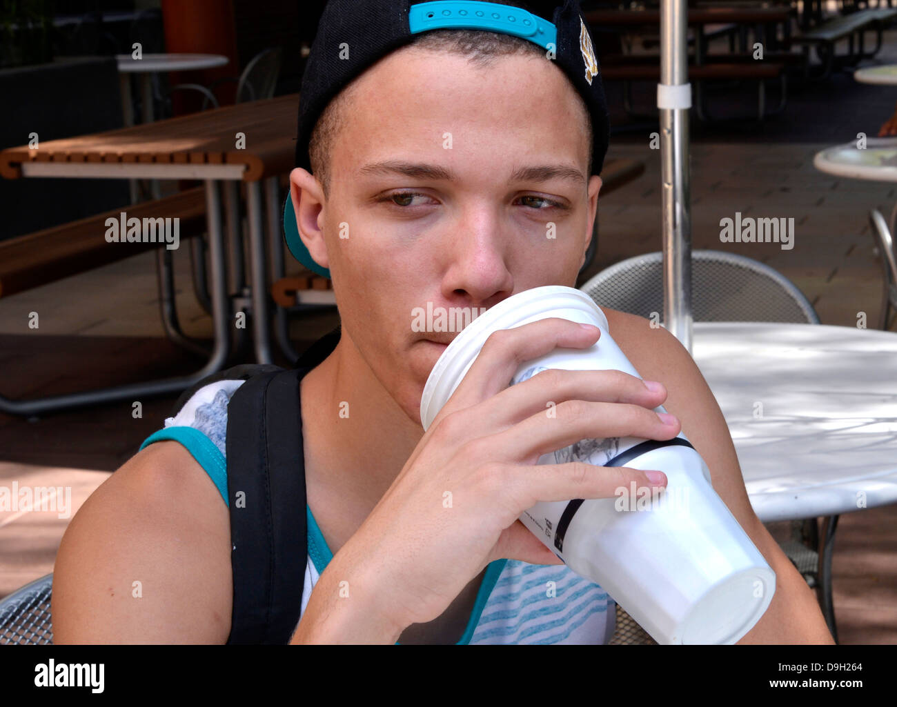 A young man drinks soda on a college campus Stock Photo - Alamy