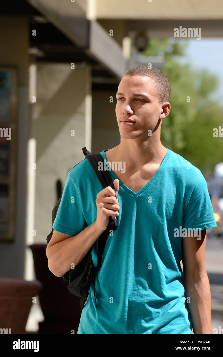A young man walks on a college campus Stock Photo - Alamy