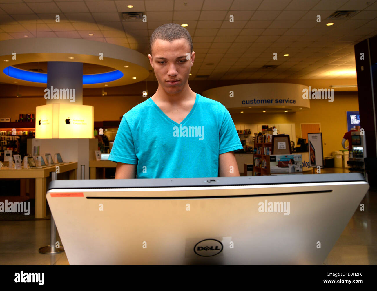 A young man looks at computers in a campus bookstore Stock Photo - Alamy