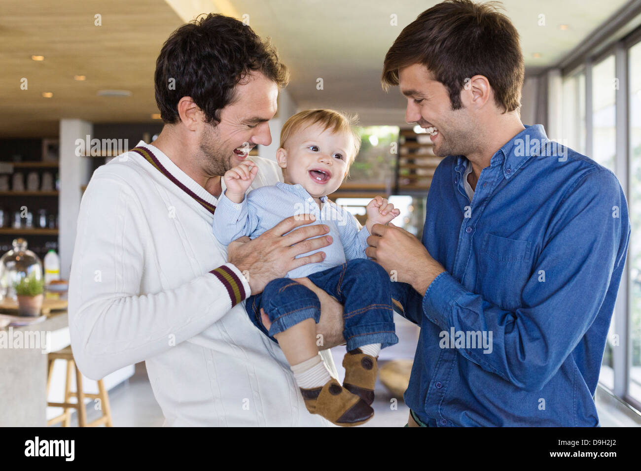 Parents smiling with their son at home Stock Photo - Alamy
