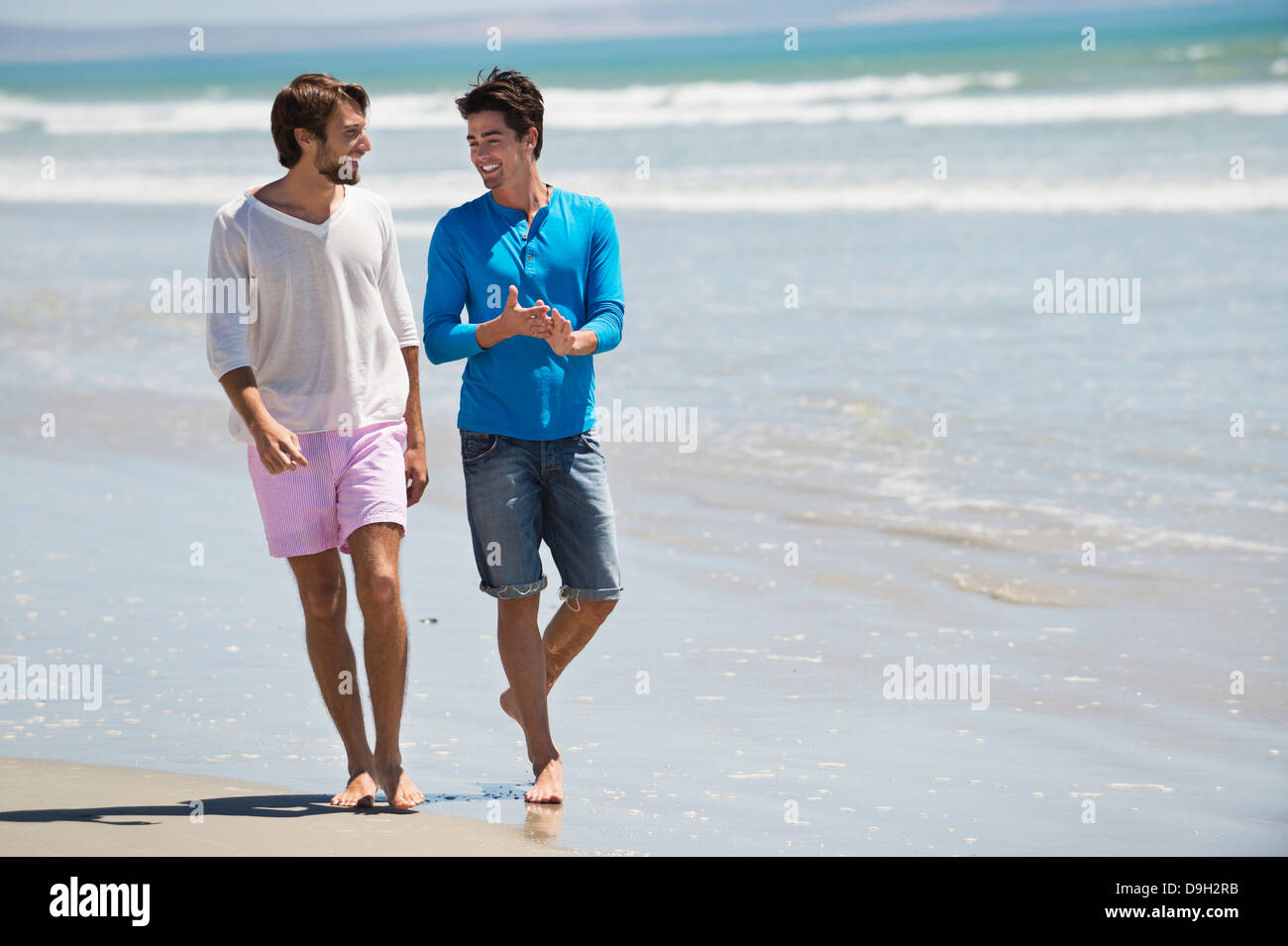 Two men walking on the beach Stock Photo - Alamy