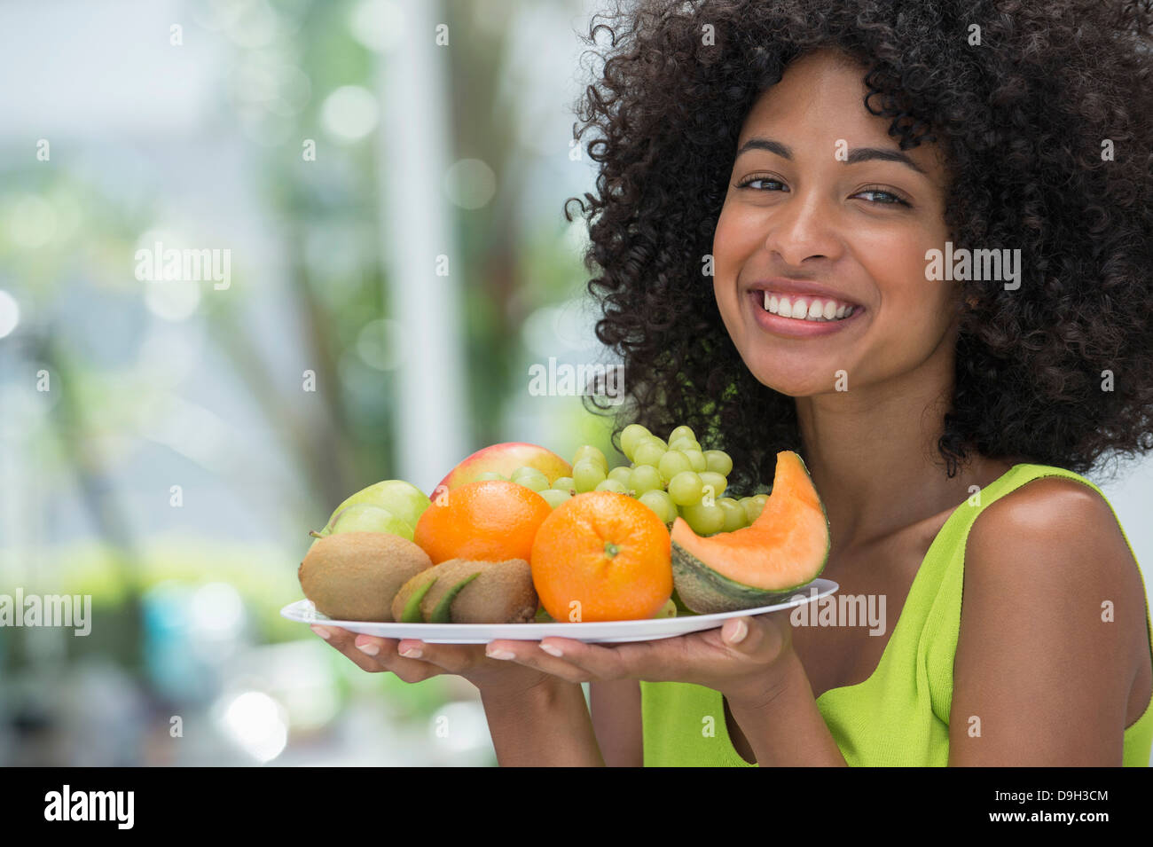 Smiling woman holding a plate of fruits Stock Photo - Alamy