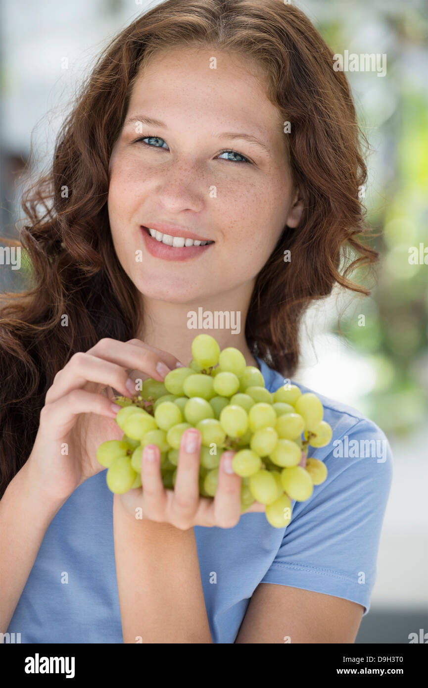 Portrait of a woman eating grapes Stock Photo - Alamy