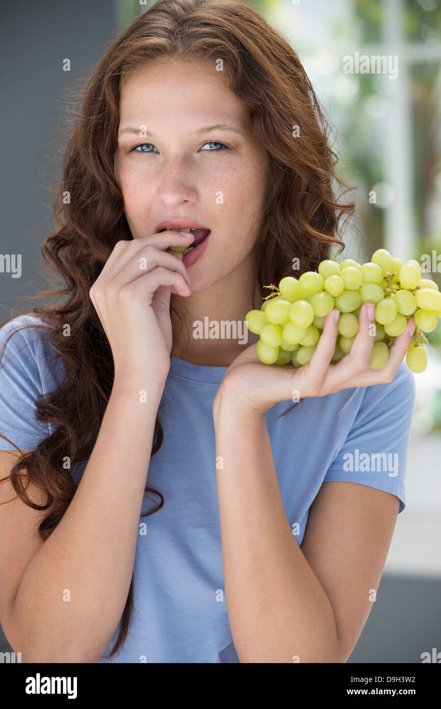 Portrait of a woman eating grapes Stock Photo - Alamy