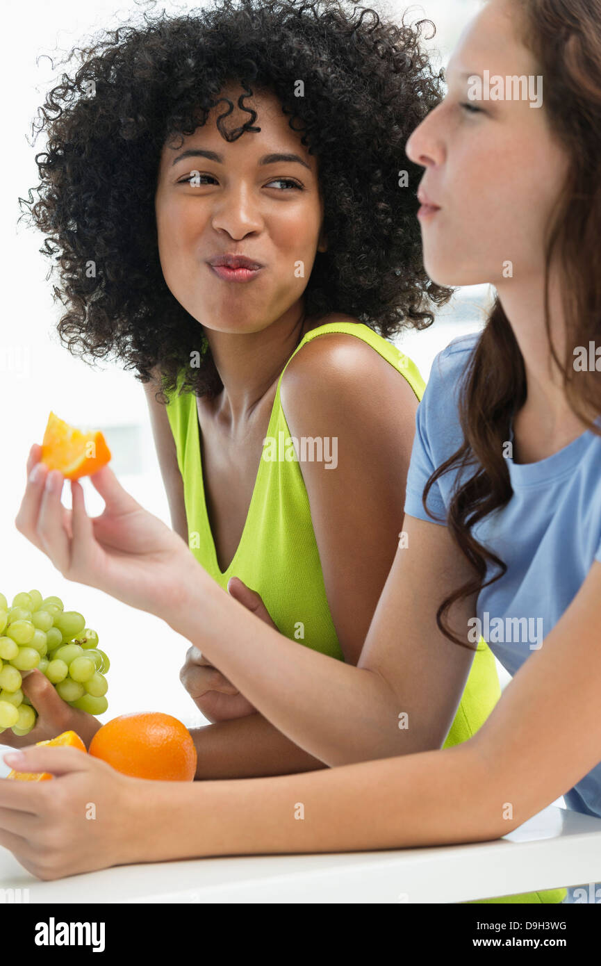 Close-up of two female friends eating fruits Stock Photo - Alamy