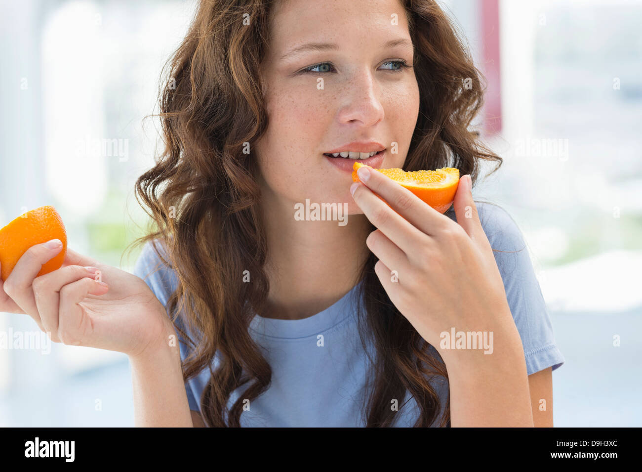 Close-up of a woman eating orange Stock Photo - Alamy