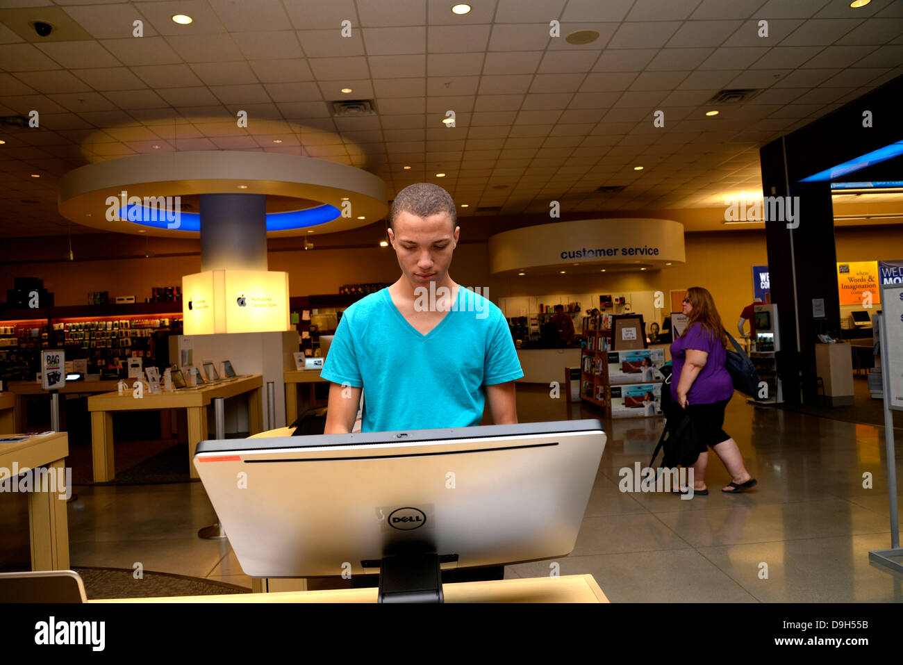 A young man looks at computers in a campus bookstore Stock Photo - Alamy