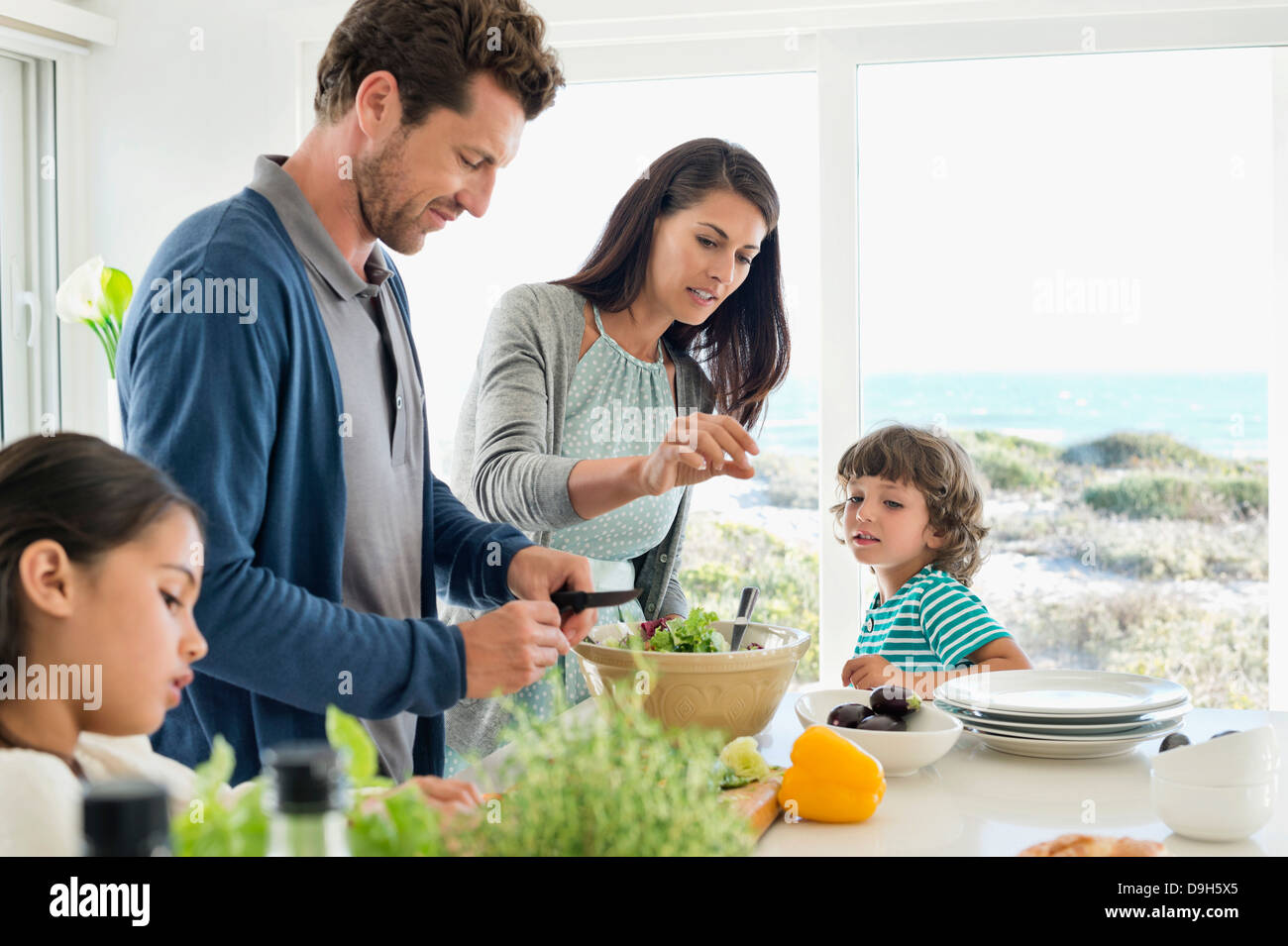 Family preparing food in the kitchen Stock Photo - Alamy