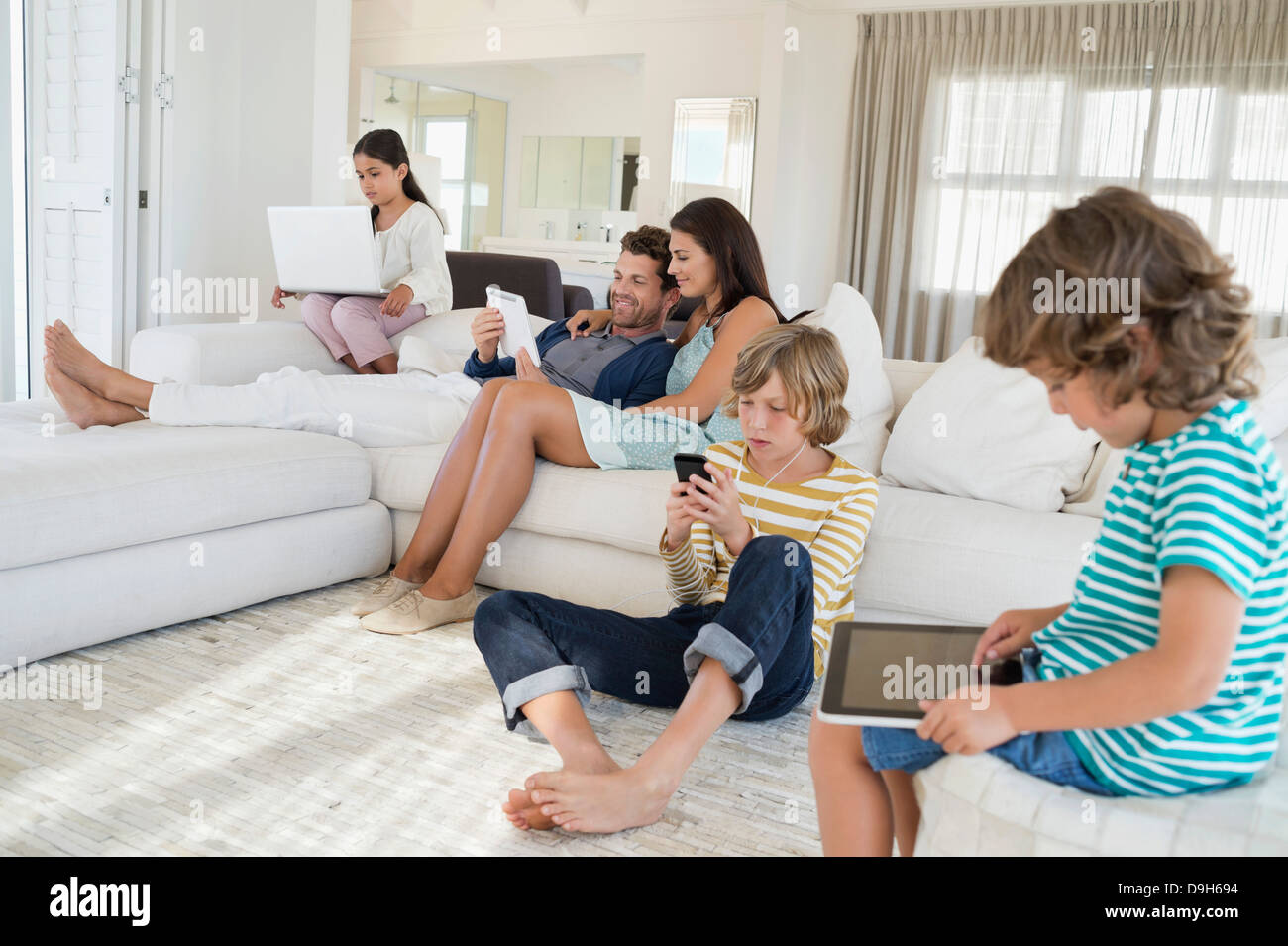 Family using electronics gadget Stock Photo - Alamy