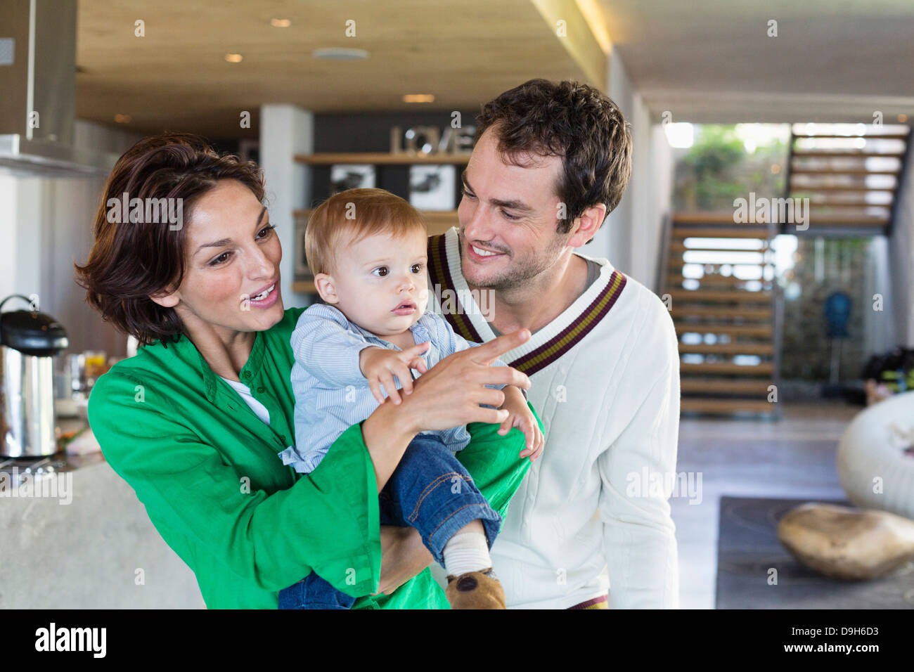Parents smiling with their son at home Stock Photo - Alamy