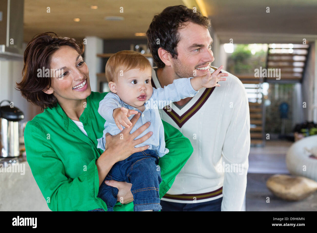 Parents smiling with their son at home Stock Photo - Alamy