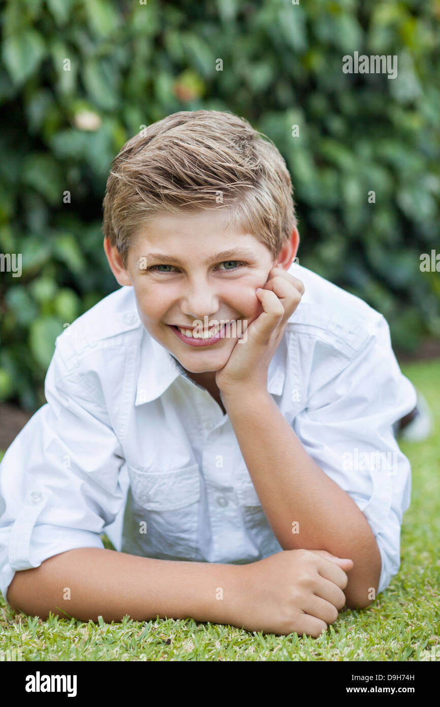 Boy lying on grass Stock Photo - Alamy