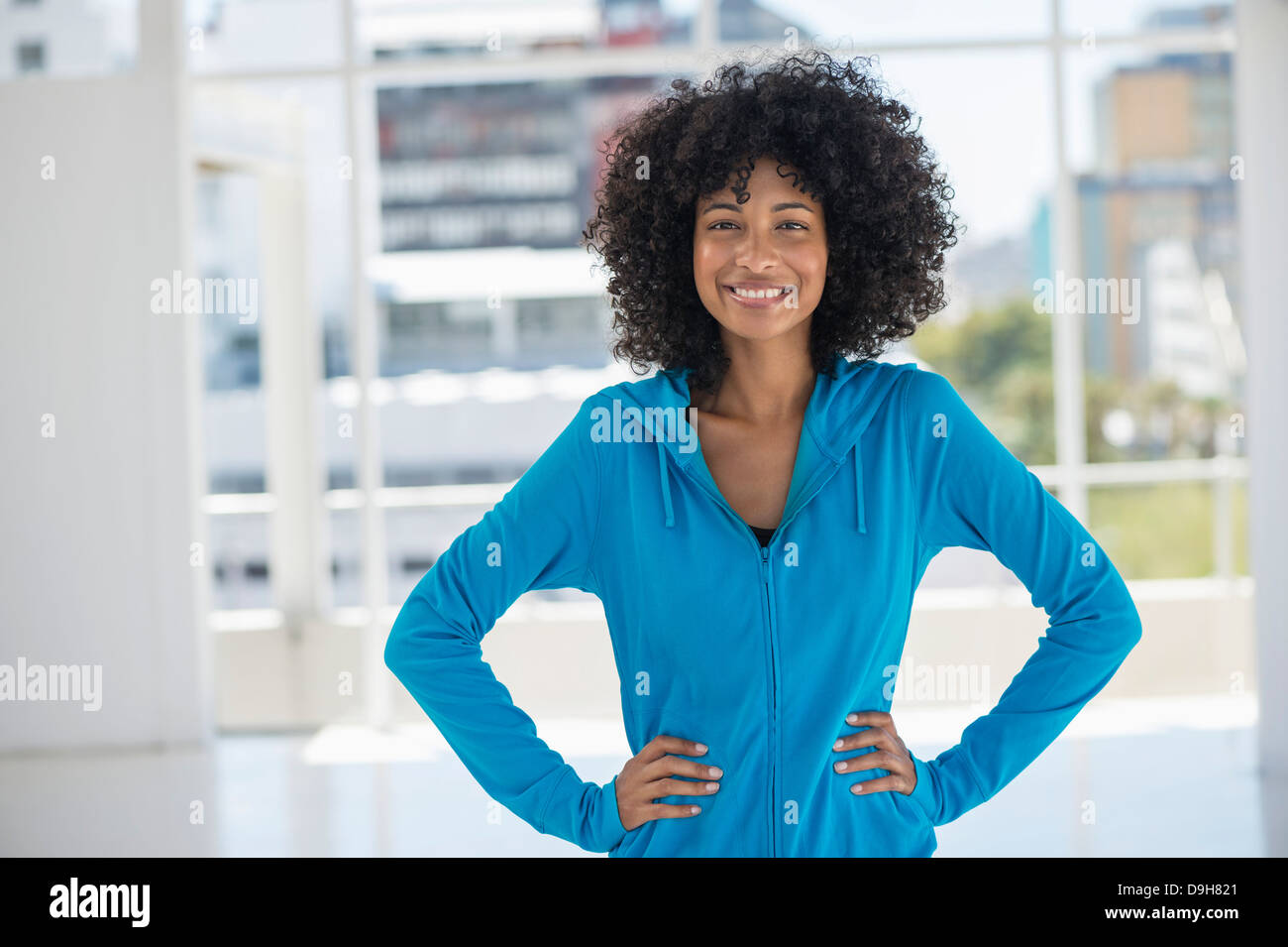 Portrait of a smiling woman standing with hands on hips Stock Photo - Alamy