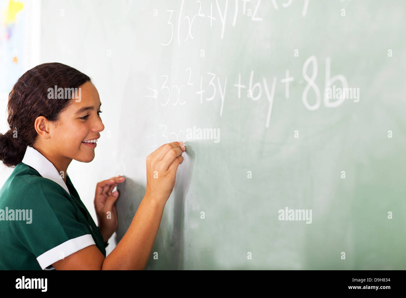 smiling young learner writing maths on the blackboard Stock Photo - Alamy