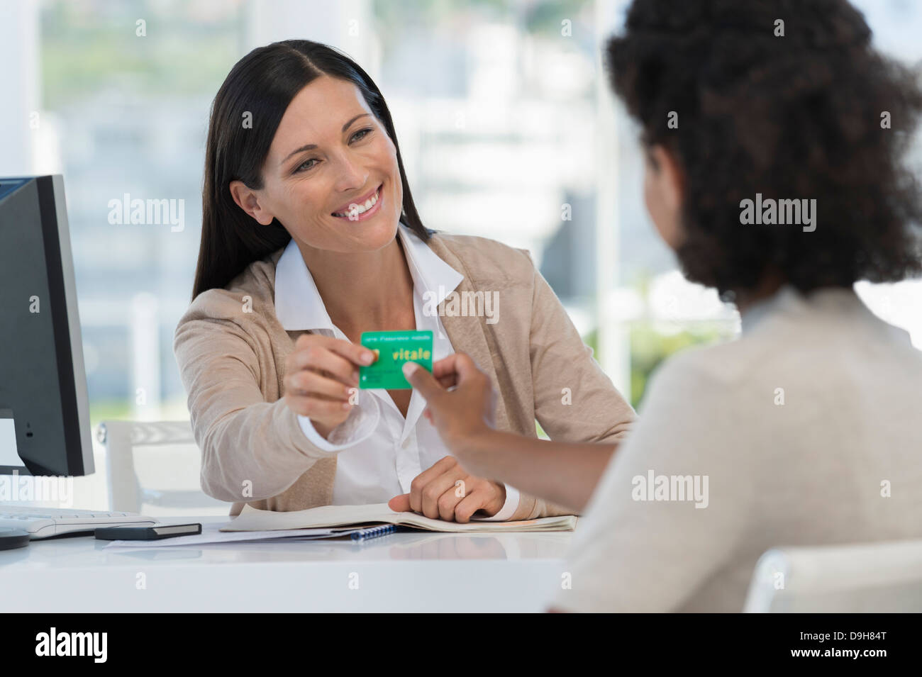 Female doctor giving a health insurance card to a patient Stock Photo ...