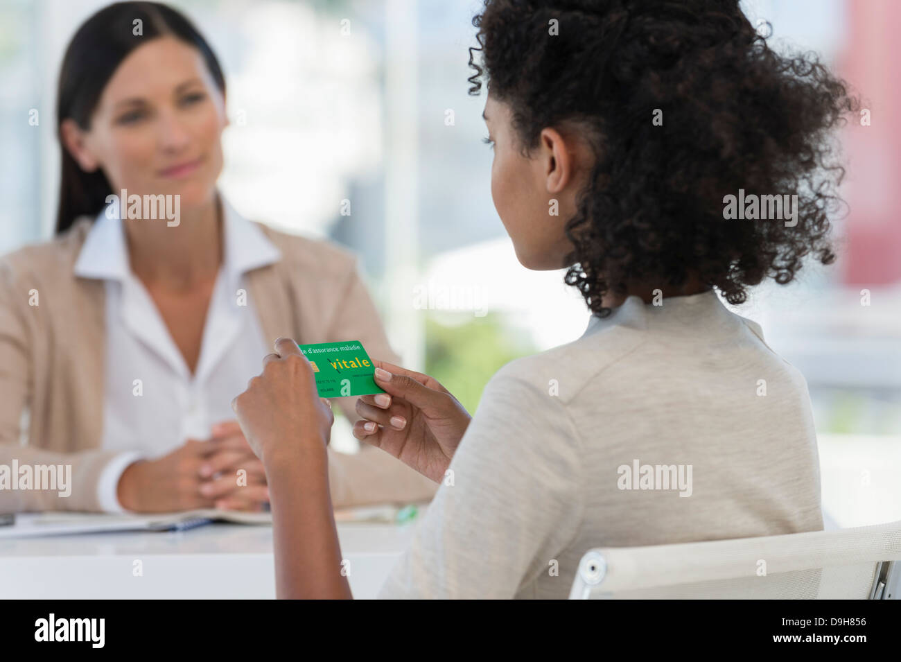Female patient looking at a health insurance card Stock Photo - Alamy