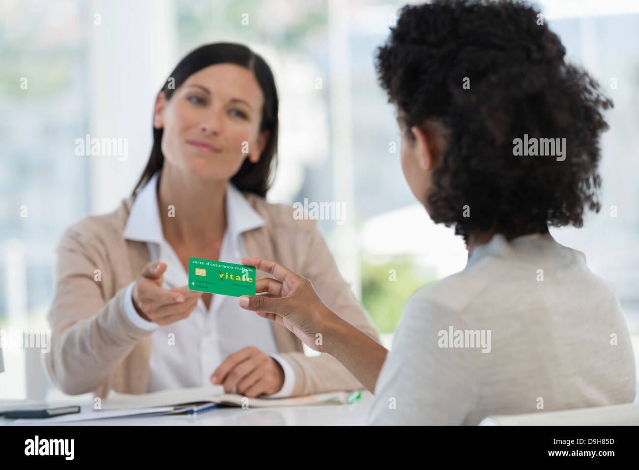 Female patient giving health insurance card to a doctor Stock Photo - Alamy