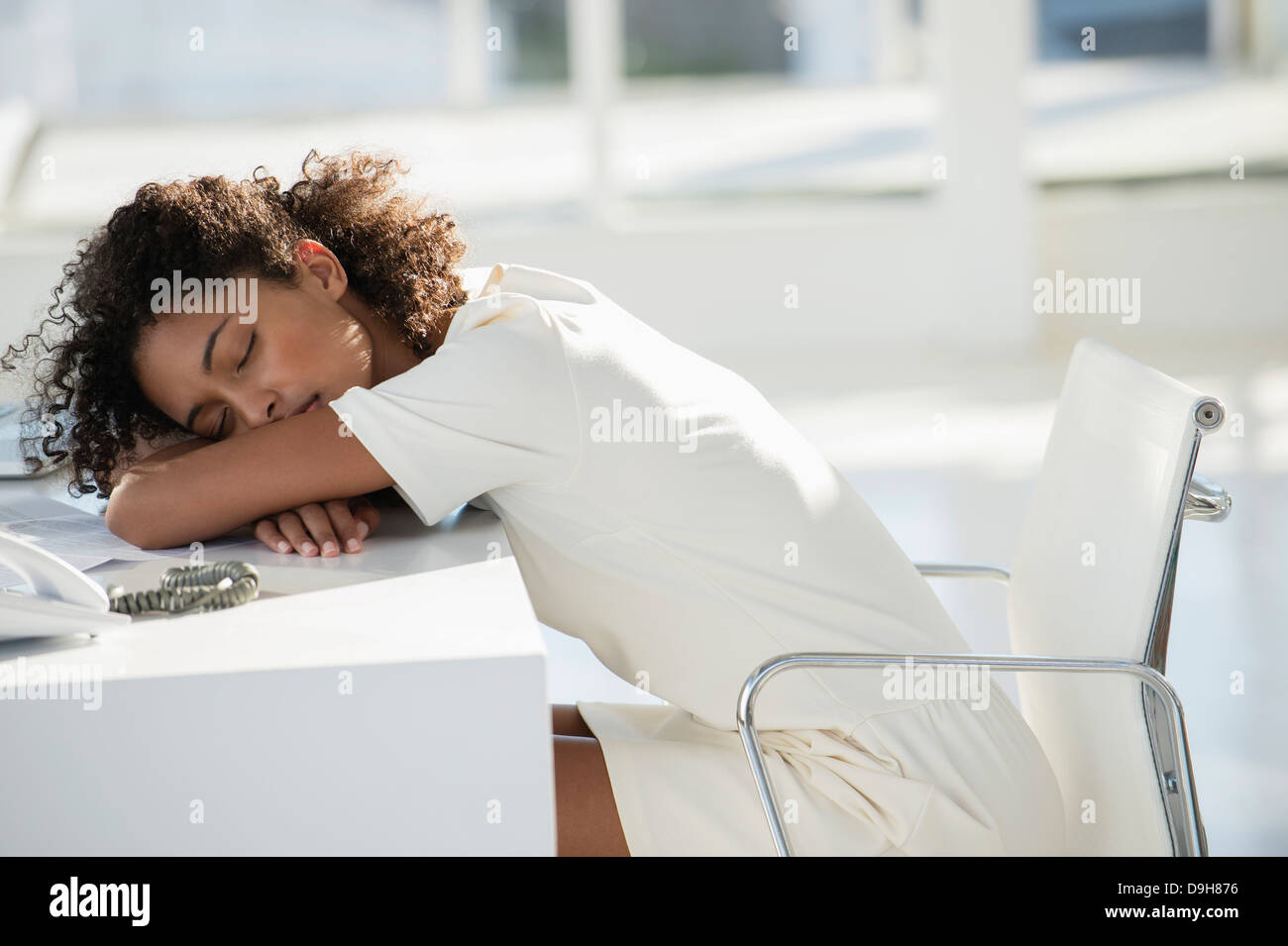 Woman napping with her head resting on desk Stock Photo - Alamy