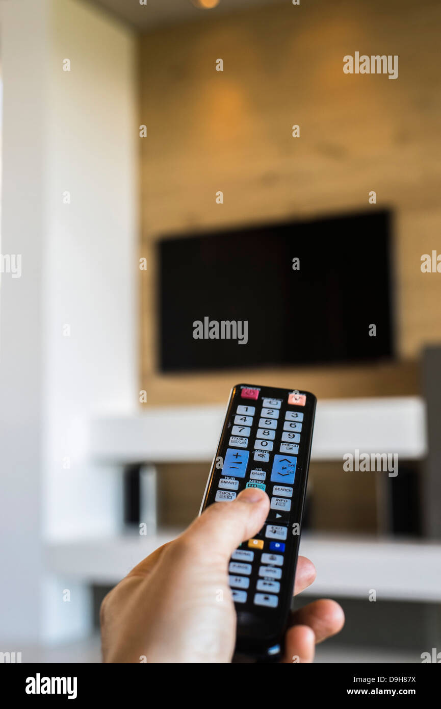 Person's hand operating a TV remote control Stock Photo - Alamy