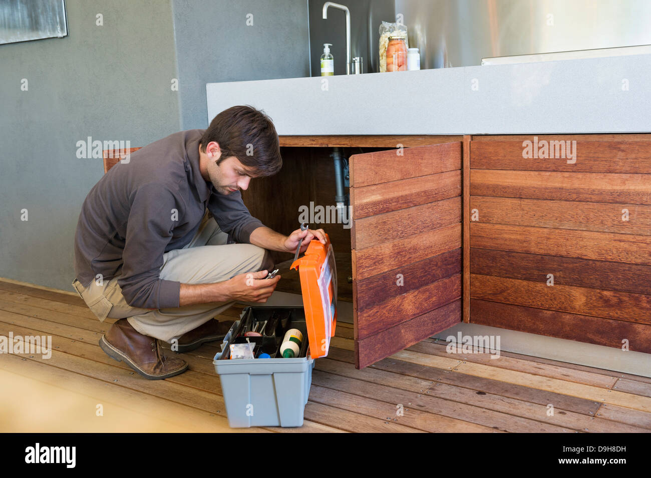 Man repairing a kitchen sink Stock Photo - Alamy