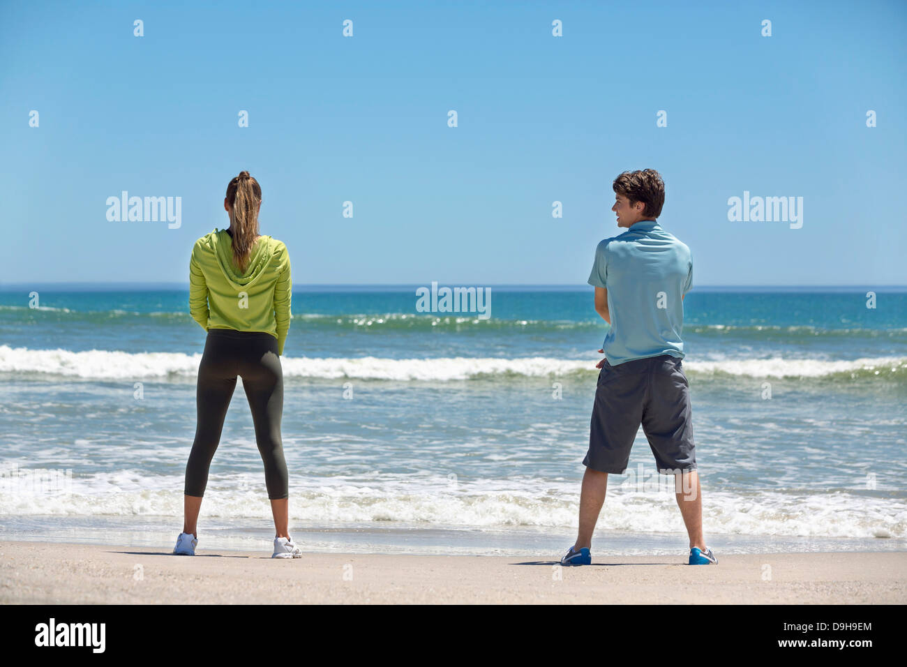 Rear view of a woman and her coach exercising on the beach Stock Photo ...