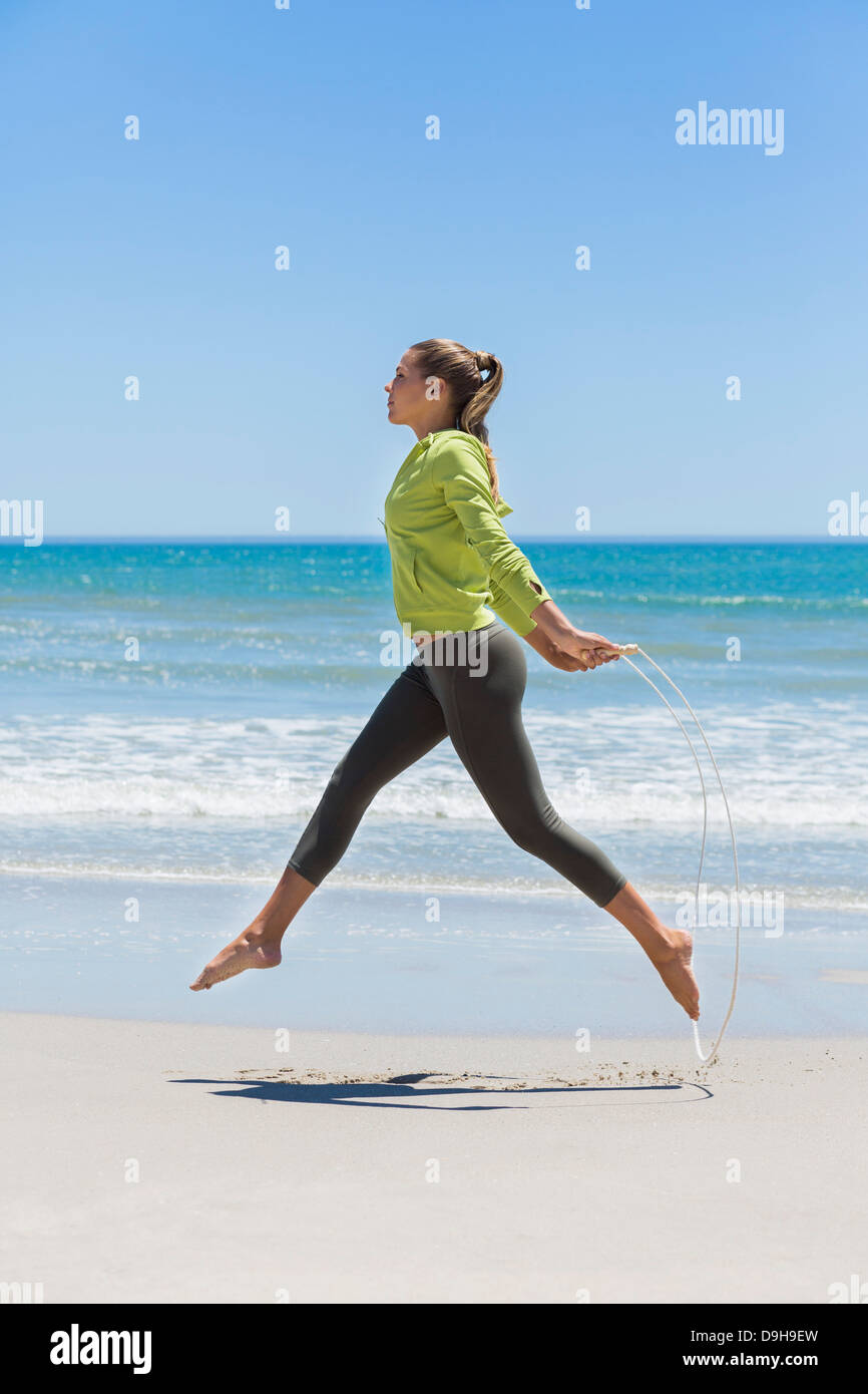 Woman jumping rope on the beach Stock Photo - Alamy