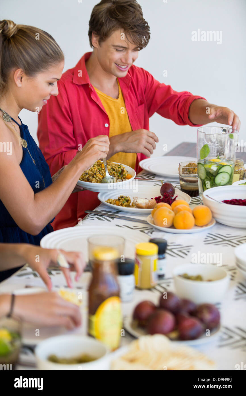 Friends sitting at a dining table having lunch Stock Photo - Alamy