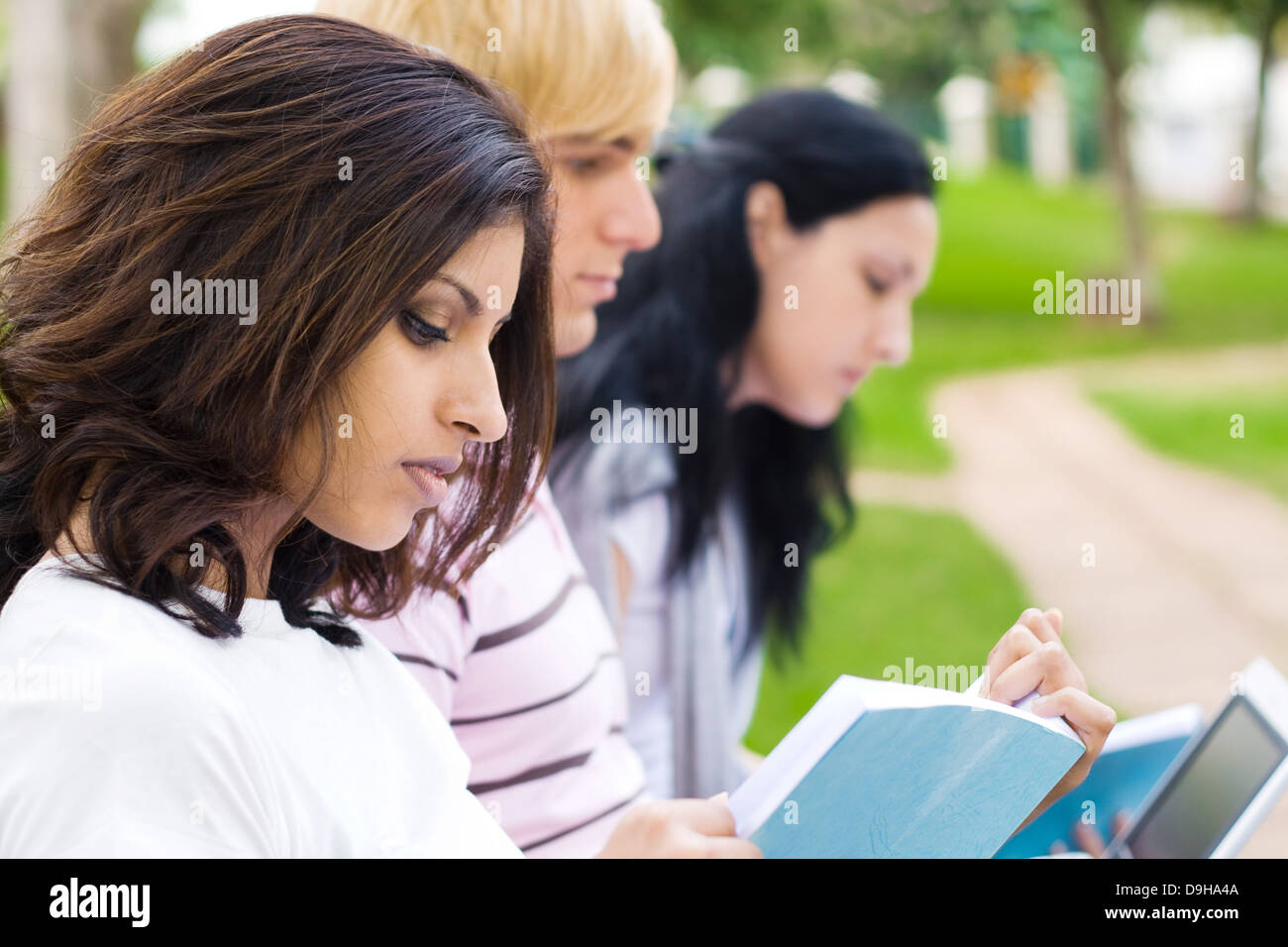 group of college students reading book Stock Photo - Alamy