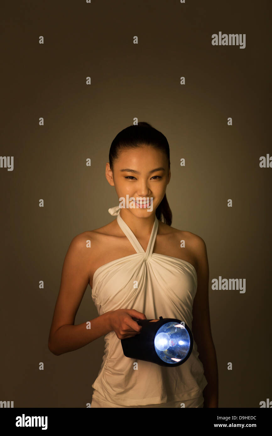 Young woman holding a flashlight Stock Photo - Alamy