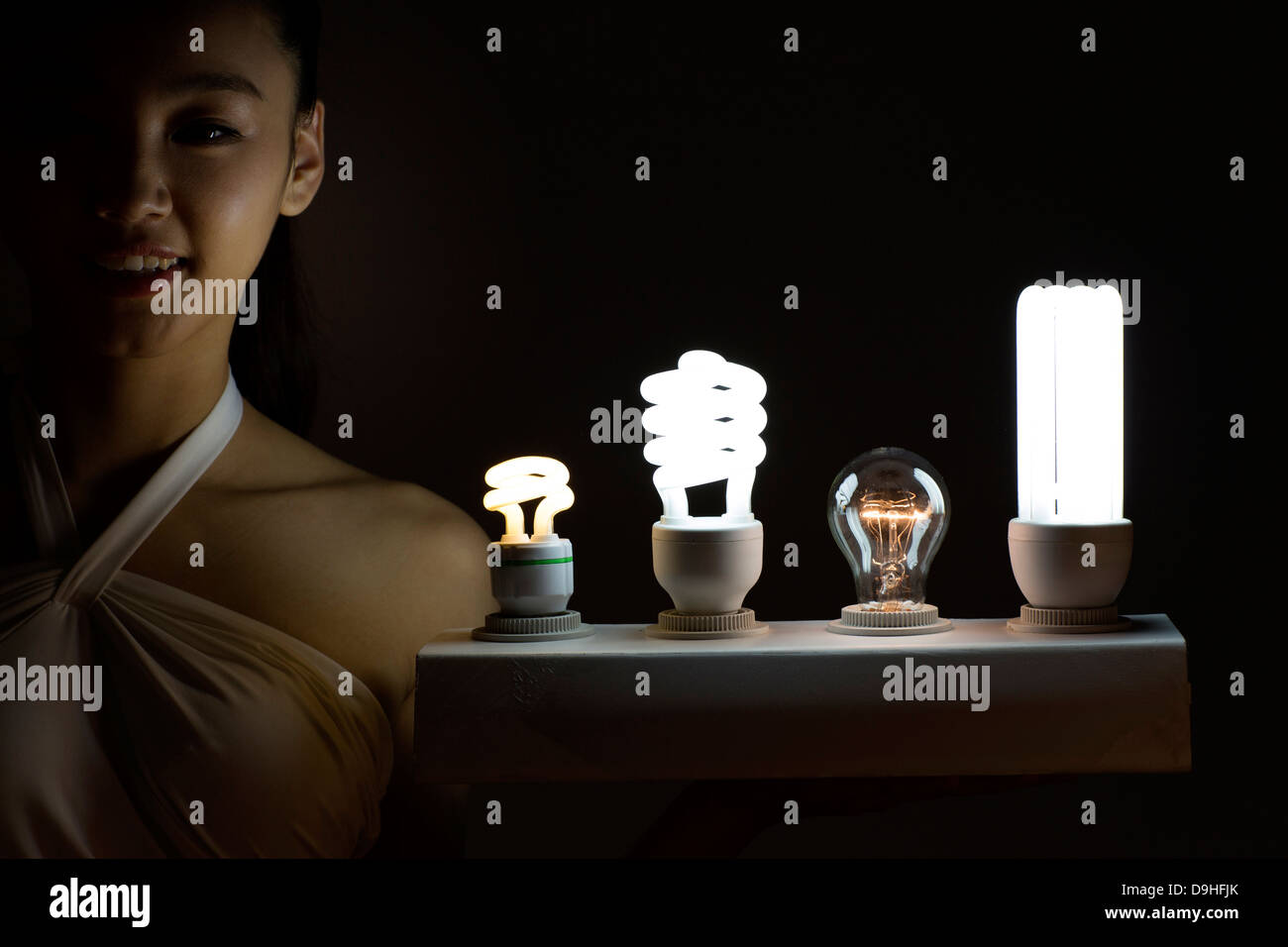 Portrait of woman holding electric bulb hi-res stock photography and ...