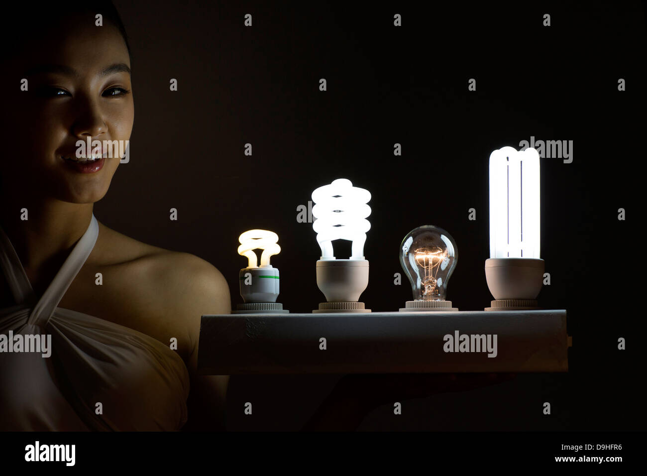 Portrait of woman holding electric bulb hi-res stock photography and ...