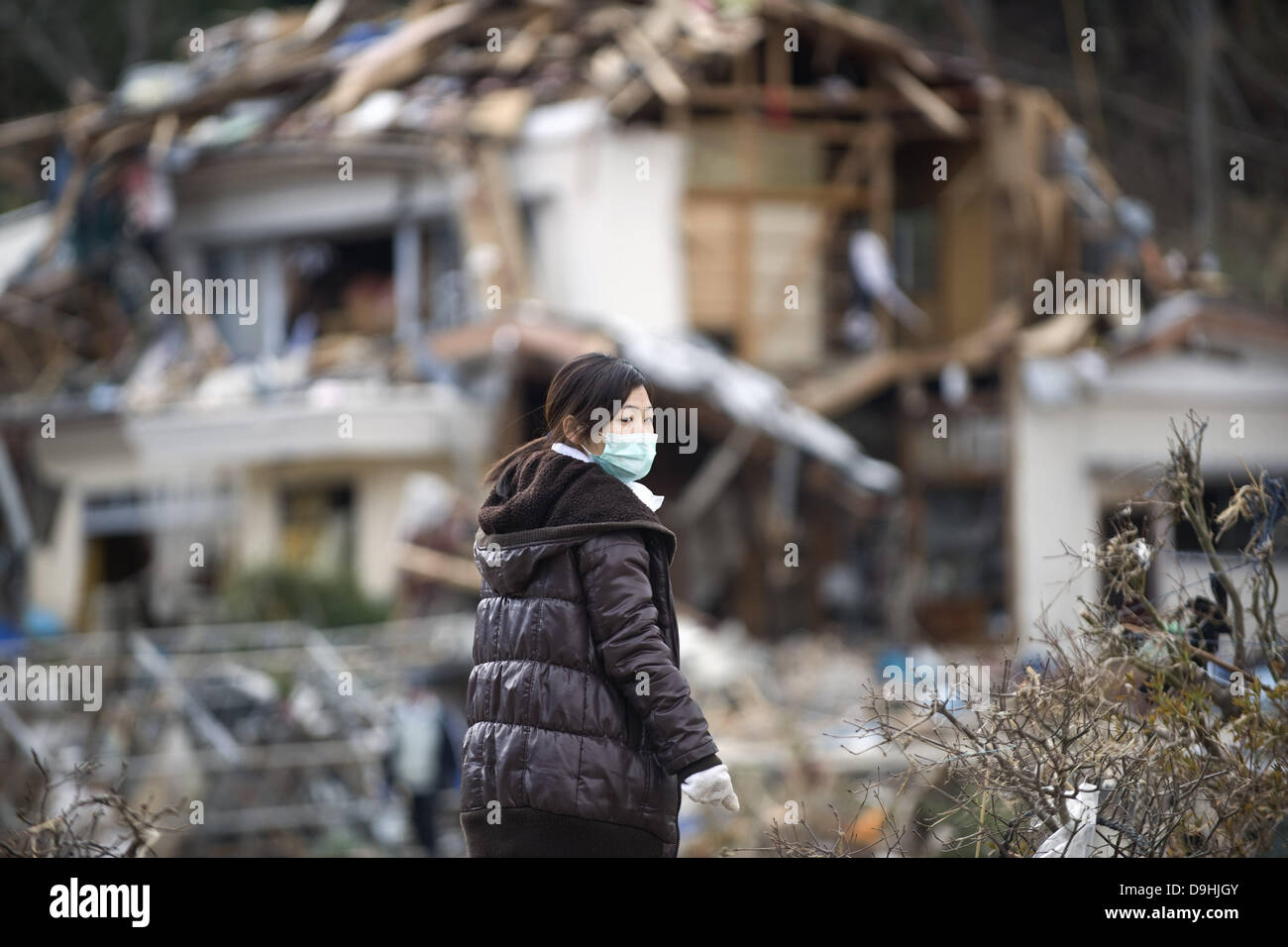Mayumi Abe looks on at the wrecked remains of her family's home at ...