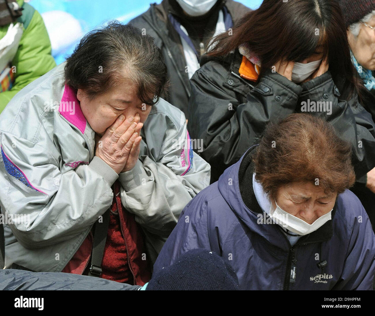 Bereaved families cry during the burial of victims of a massive ...