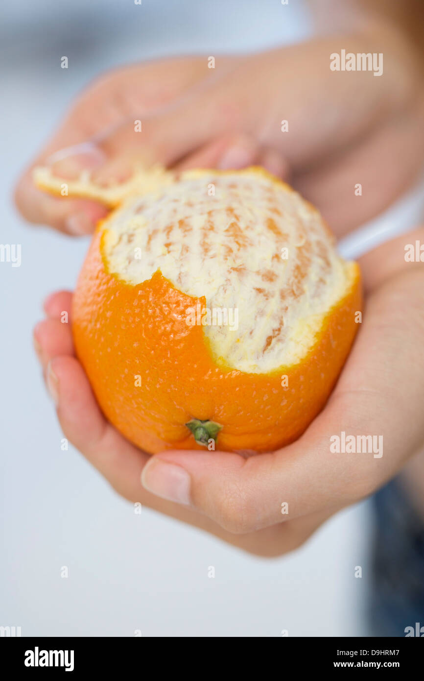 Close-up of a woman's hand peeling an orange Stock Photo - Alamy