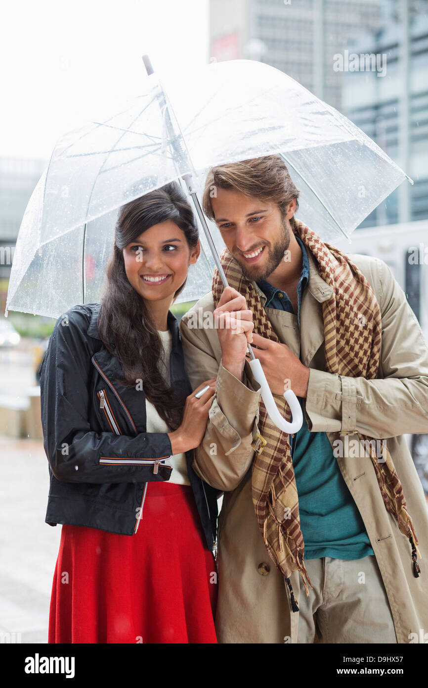 Smiling couple under umbrella Stock Photo - Alamy
