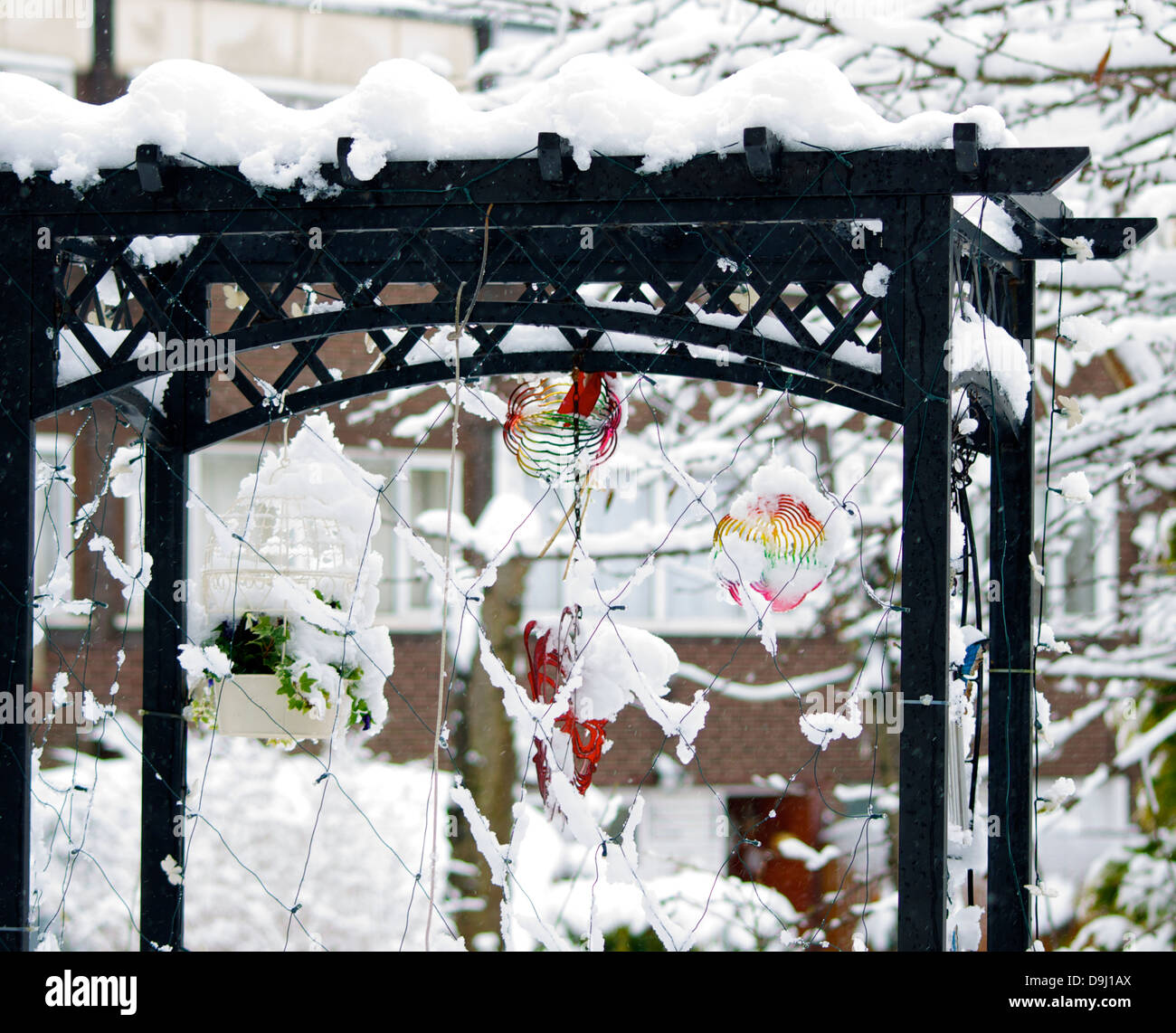 Snow covered archway in a garden Stock Photo - Alamy