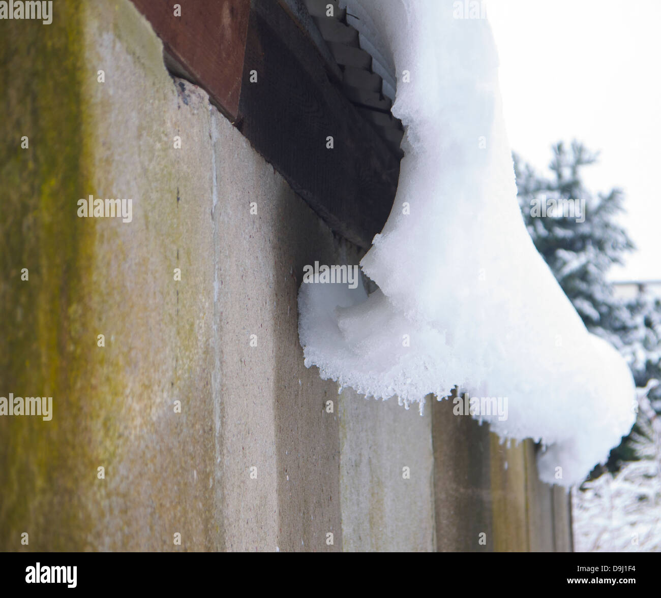 Snow hanging over the edge of a roof Stock Photo - Alamy
