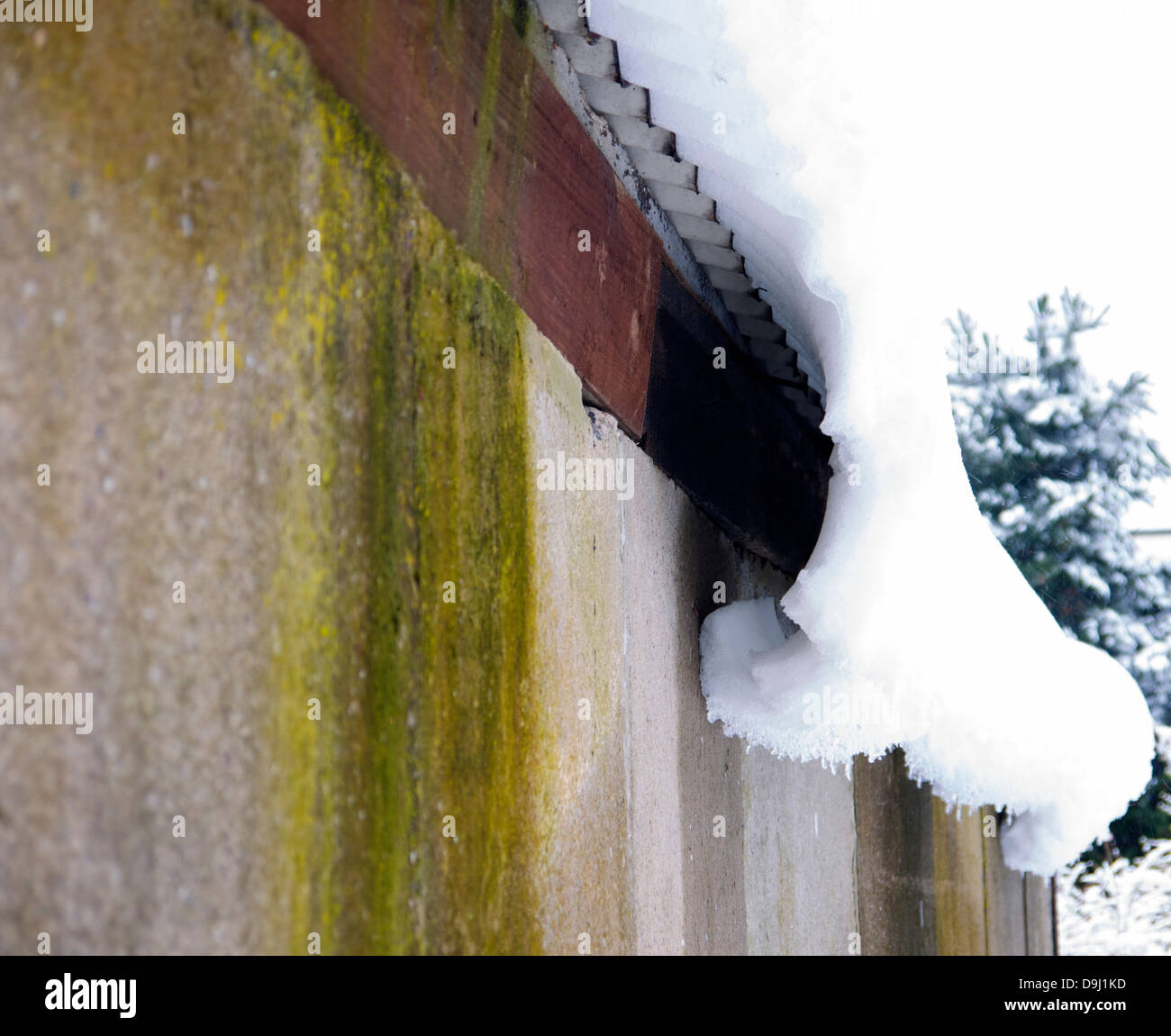 Snow hanging over the edge of a roof Stock Photo - Alamy