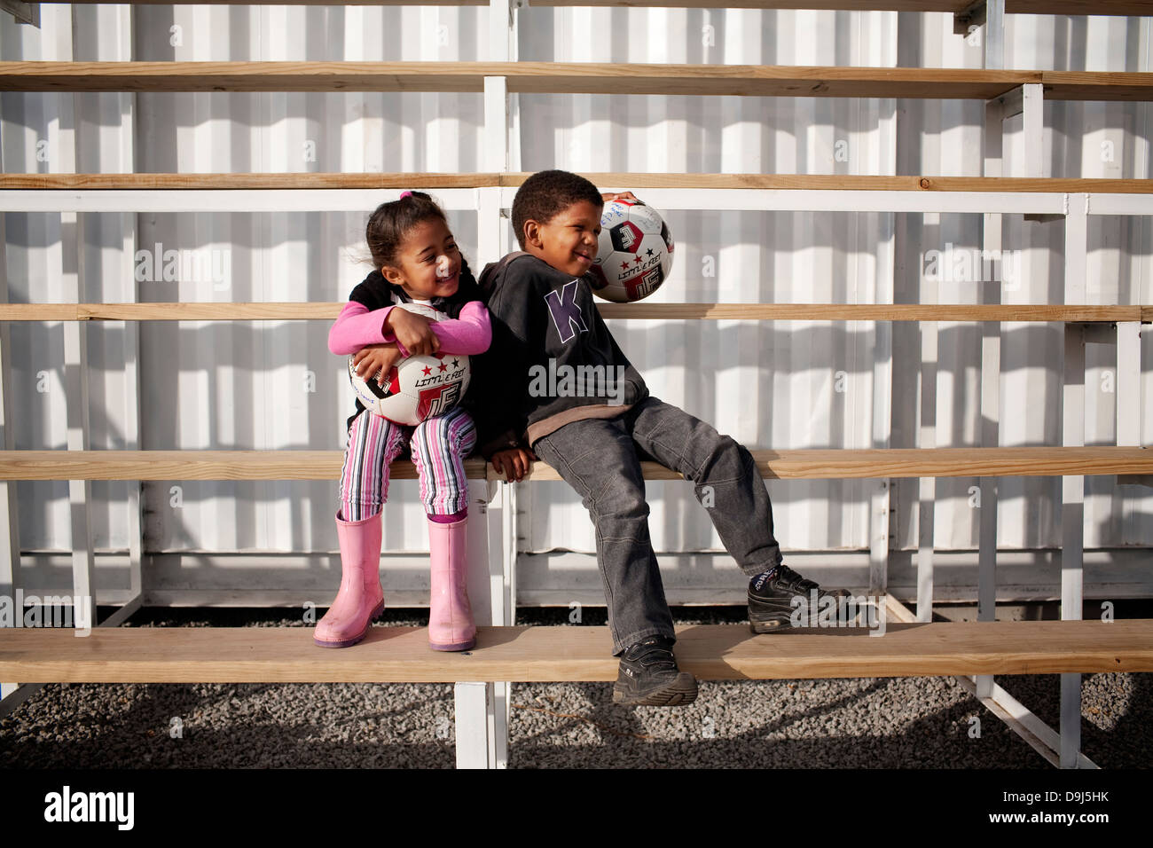 Young kids holding a football sit on the football stand in Stompneus ...