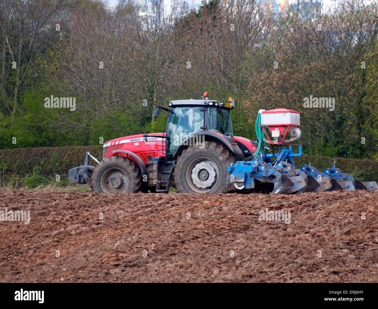 Farmer using a tractor to plough the field Stock Photo - Alamy