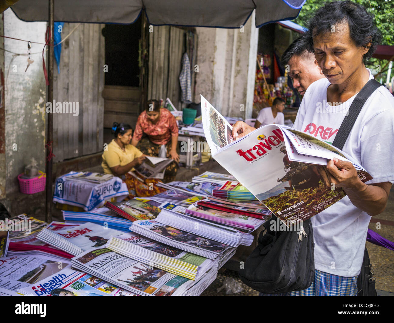 June 16, 2013 - Yangon, Union of Myanmar - A man reads a newspaper at a ...