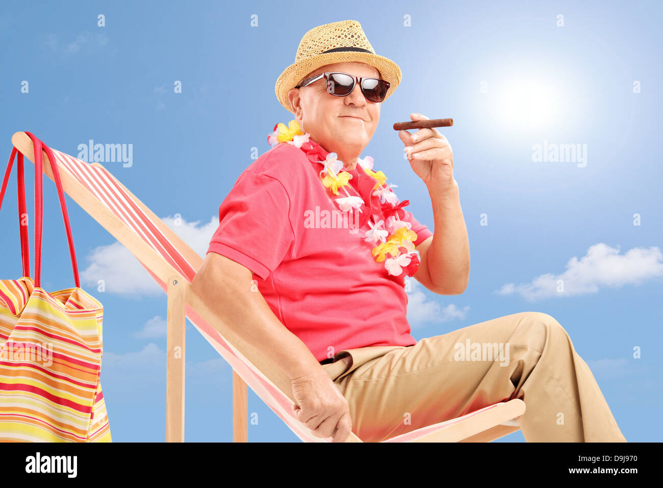 Gentleman smoking a cigar and enjoying on a beach chair on a sunny day ...