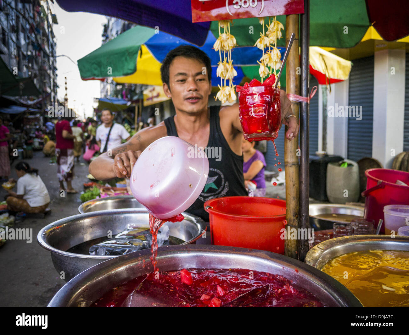 June 16, 2013 - Yangon, Union of Myanmar - A juice vendor works in a ...